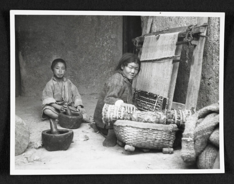 Boy grinding indigo and woman weaving a carpet, Pen-jor Lhun-po, near ...